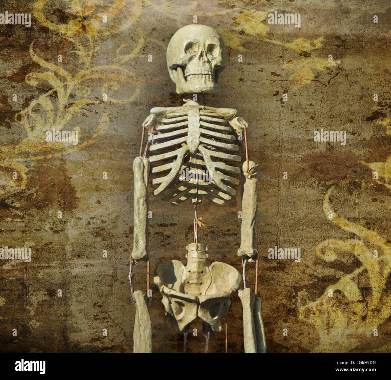 Concept image of a human skeleton hanging against a yellow textured ...