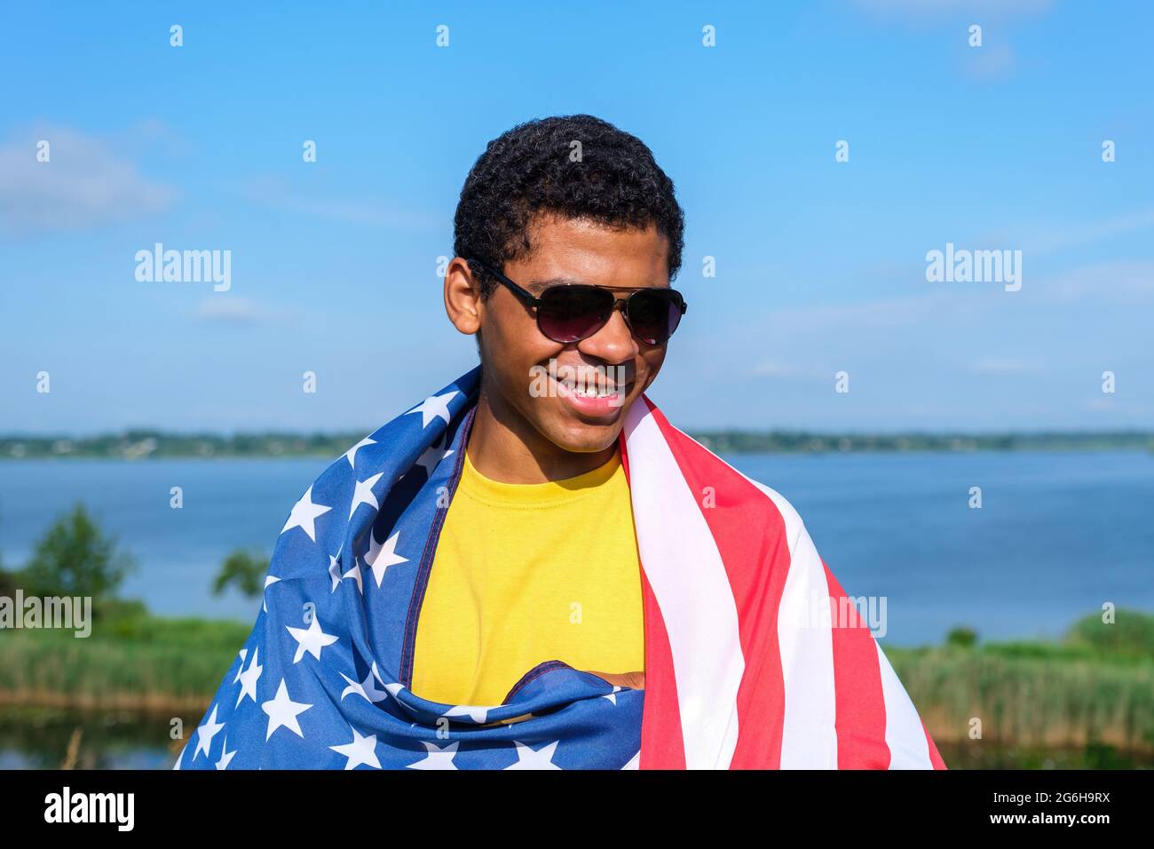 Man looking at camera and proudly holding American flag on his ...