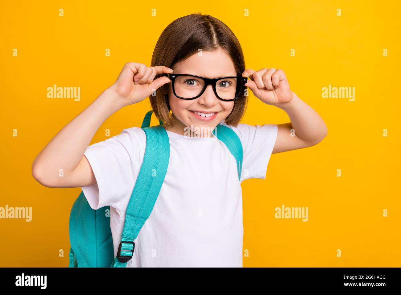 Photo portrait small schoolgirl smiling wearing glasses blue backpack ...