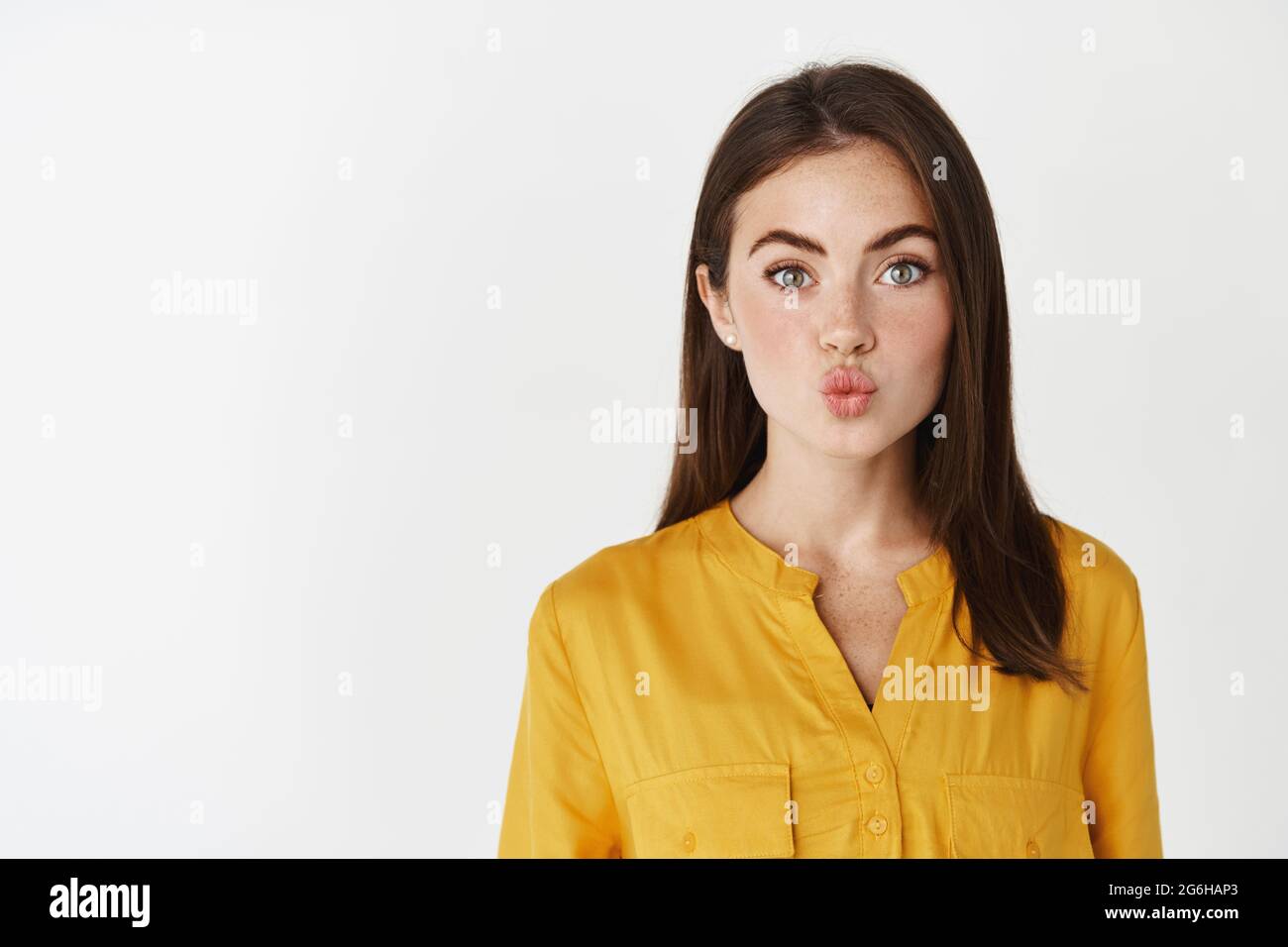 Close-up of silly and cute girl pucker lips, making kissing shape and ...