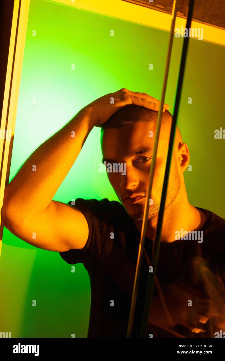 Cinematic portrait of handsome young man in neon lighted room, stylish ...