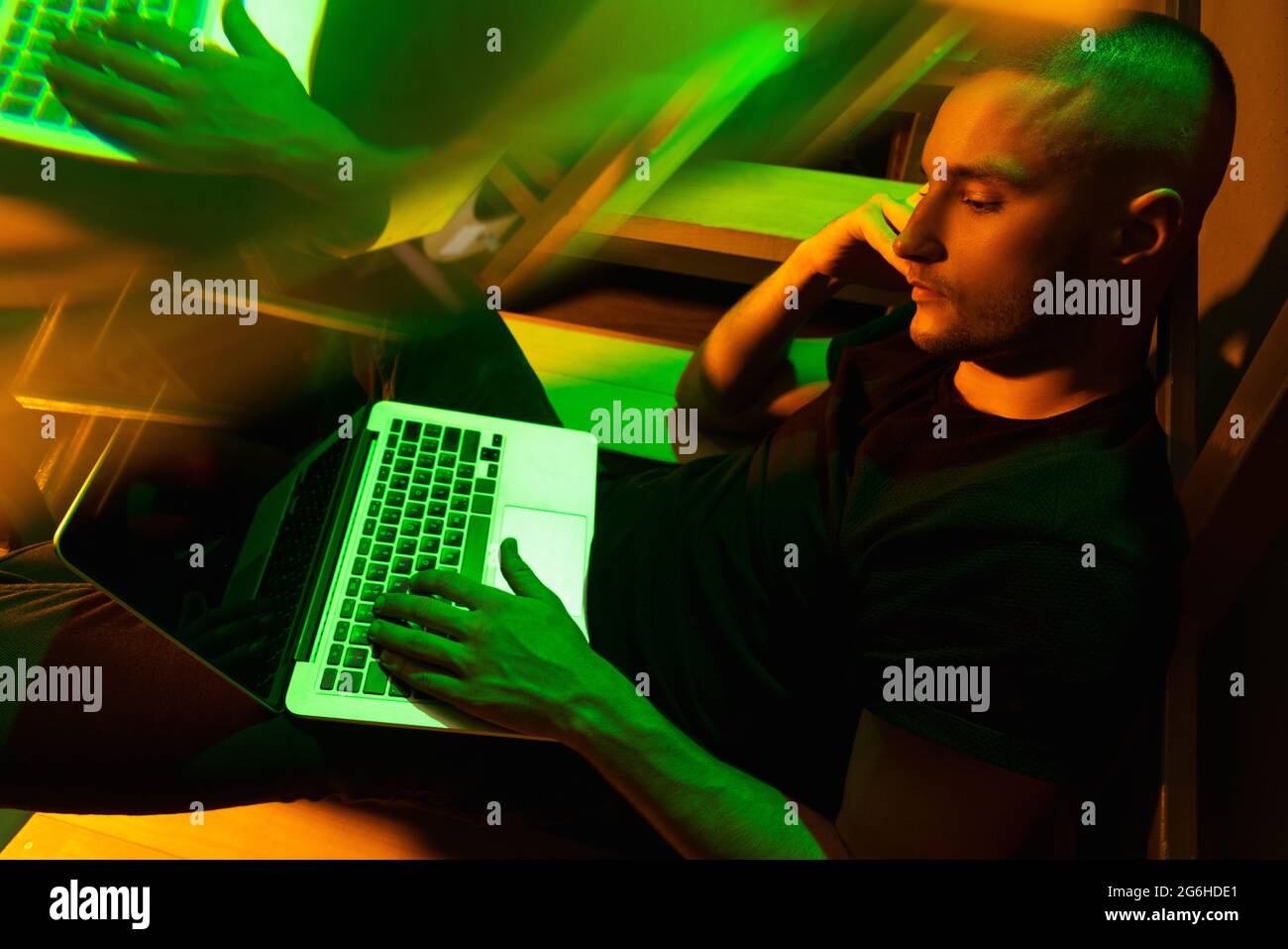 Reflection. Cinematic portrait of handsome young man in neon lighted ...