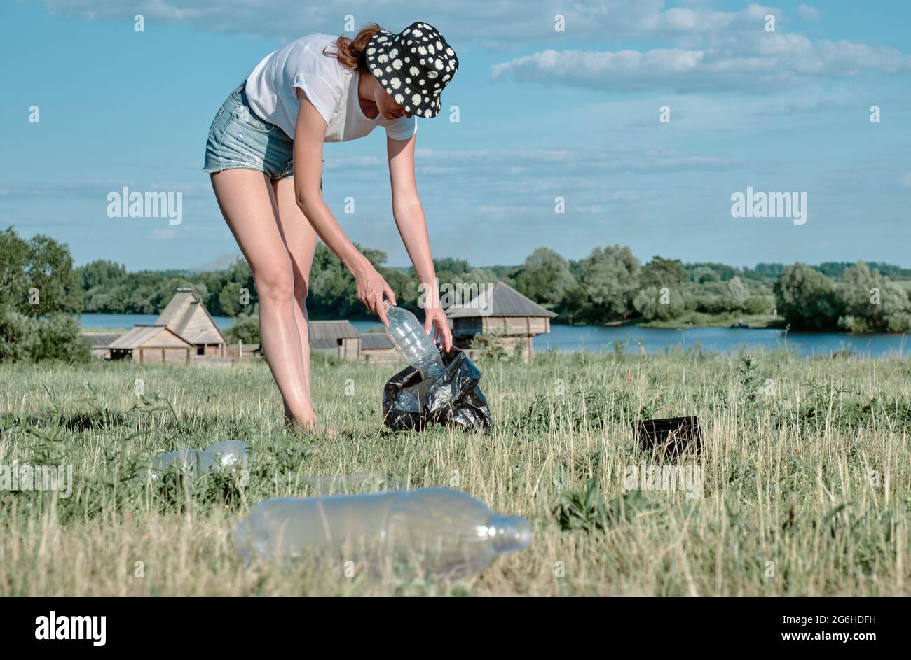 Collecting plastic garbage. The girl collects plastic bottles ...