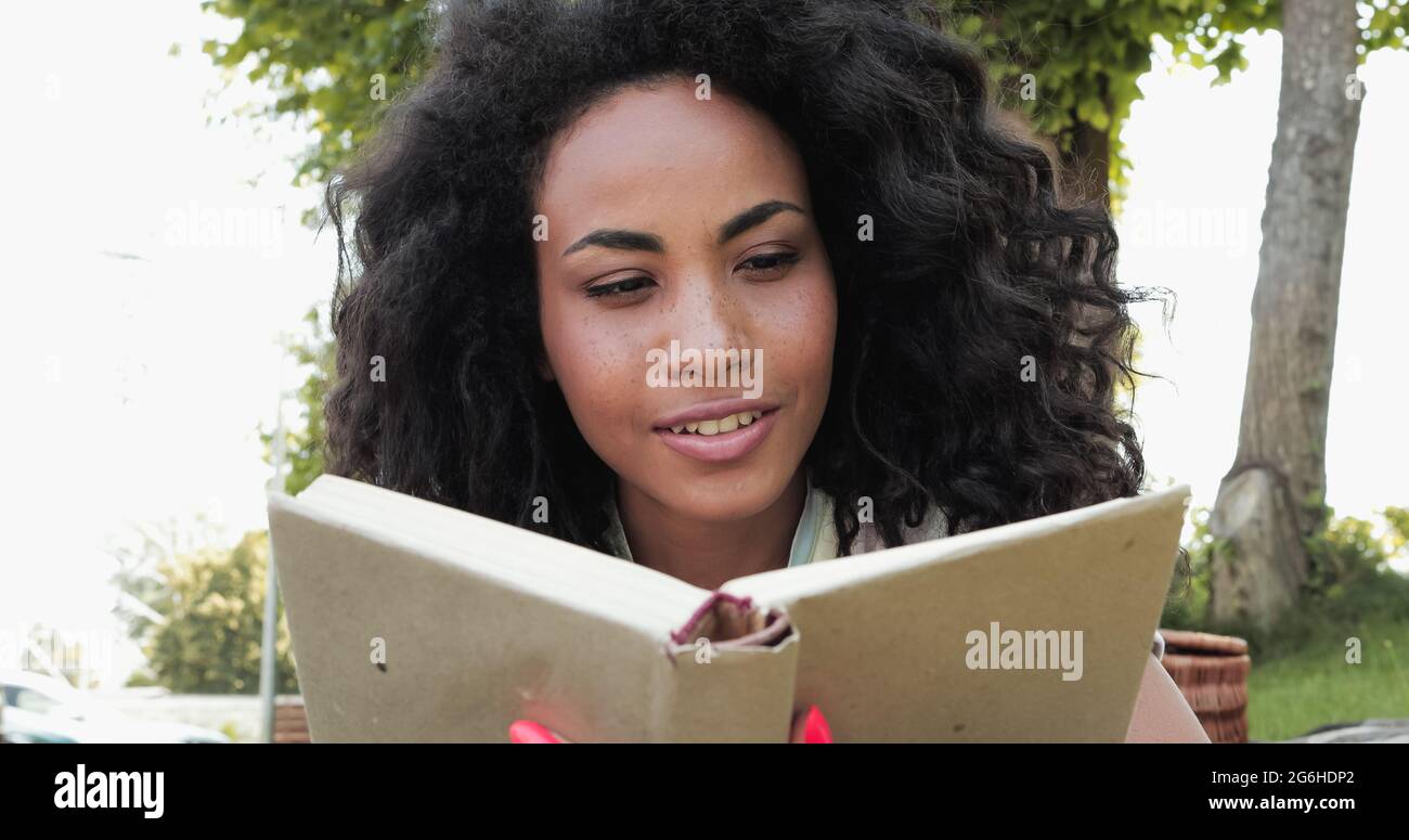 Pleased brunette african woman reading hi-res stock photography and ...