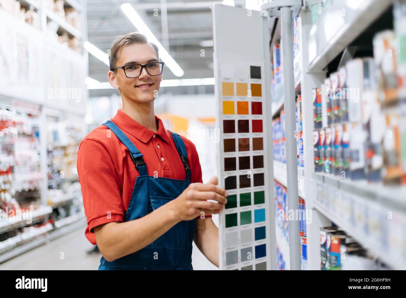 smiling construction store clerk standing near the color palette ...