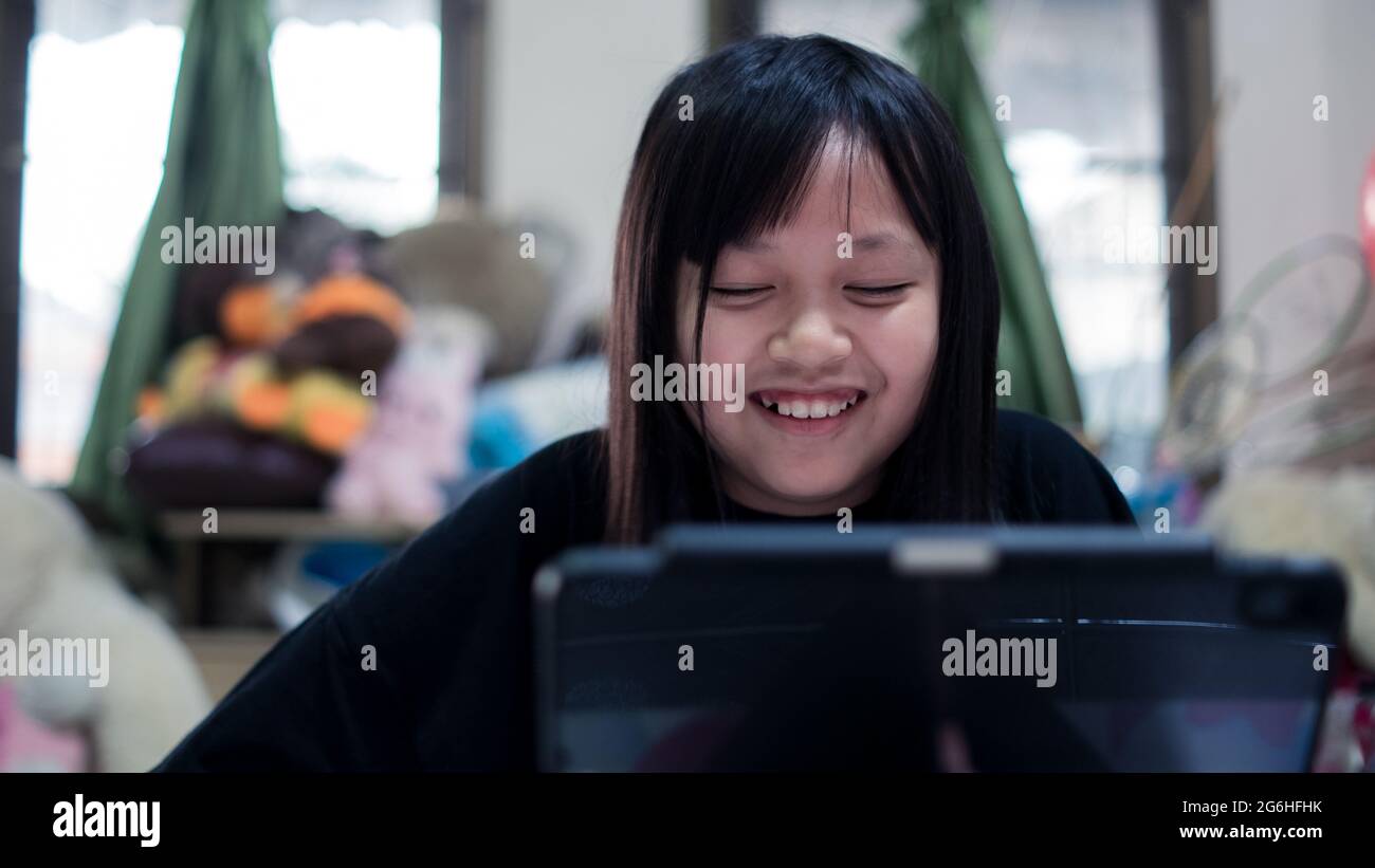 Little child girl looking tablet distance learning class watching ...