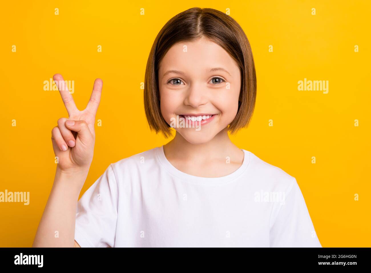 Photo of cute charming school girl wear white t-shirt smiling showing v ...