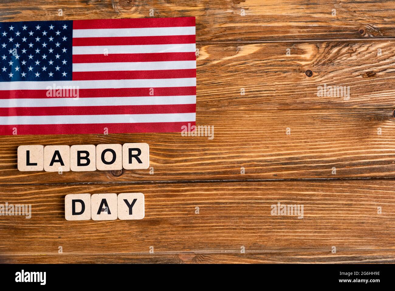 top view of usa flag near cubes with labor day lettering on wooden ...