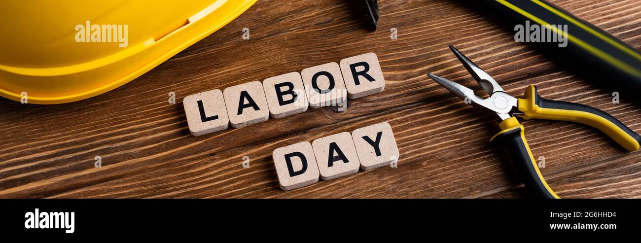 top view of pliers near helmet and cubes with labor day lettering ...