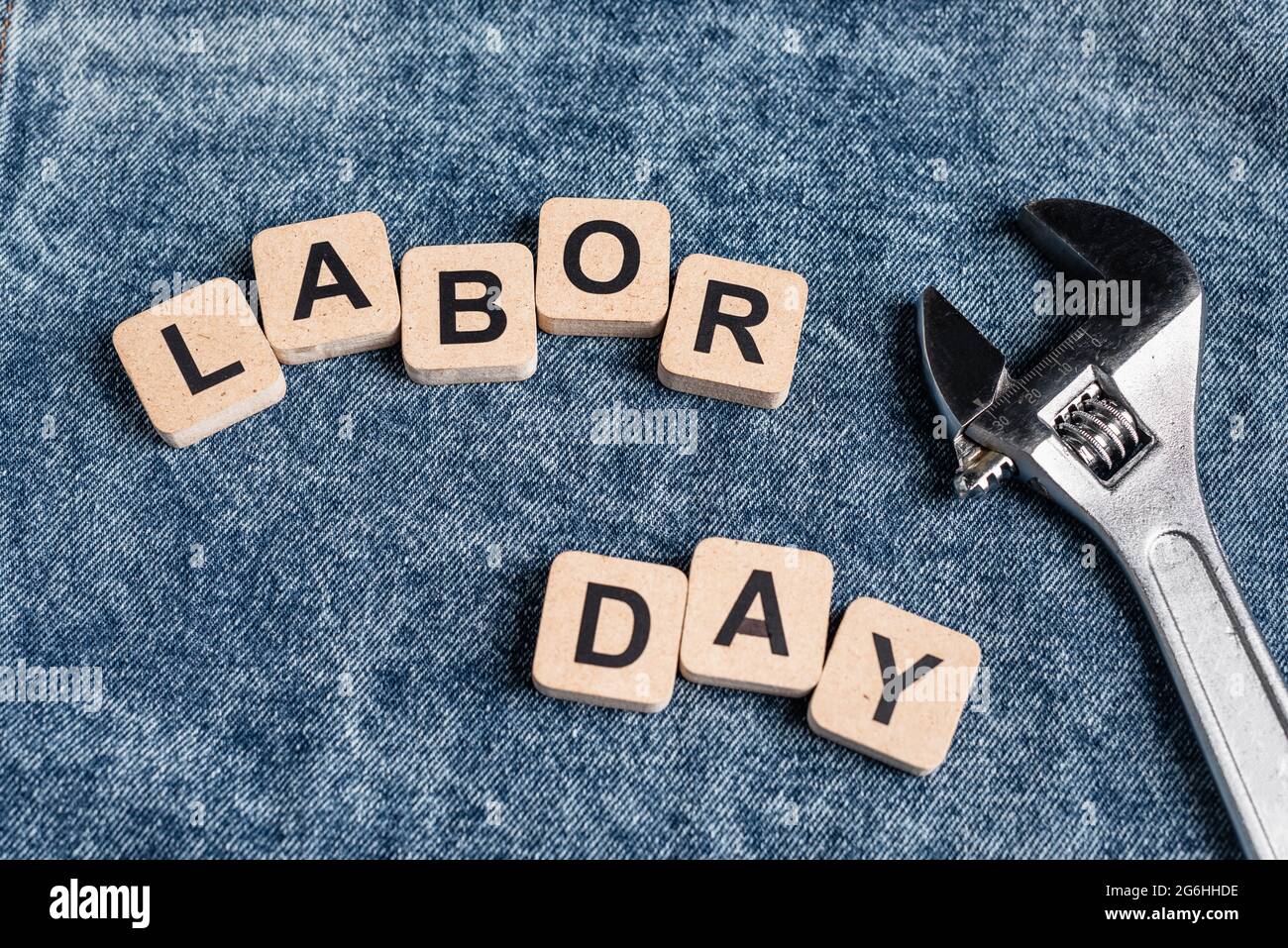top view of cubes with labor day lettering near wrench on denim clothes ...