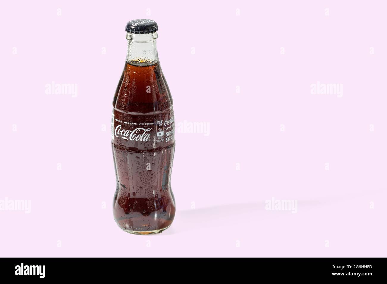 Close up view of Coca Cola in a glass bottle isolated on pink ...