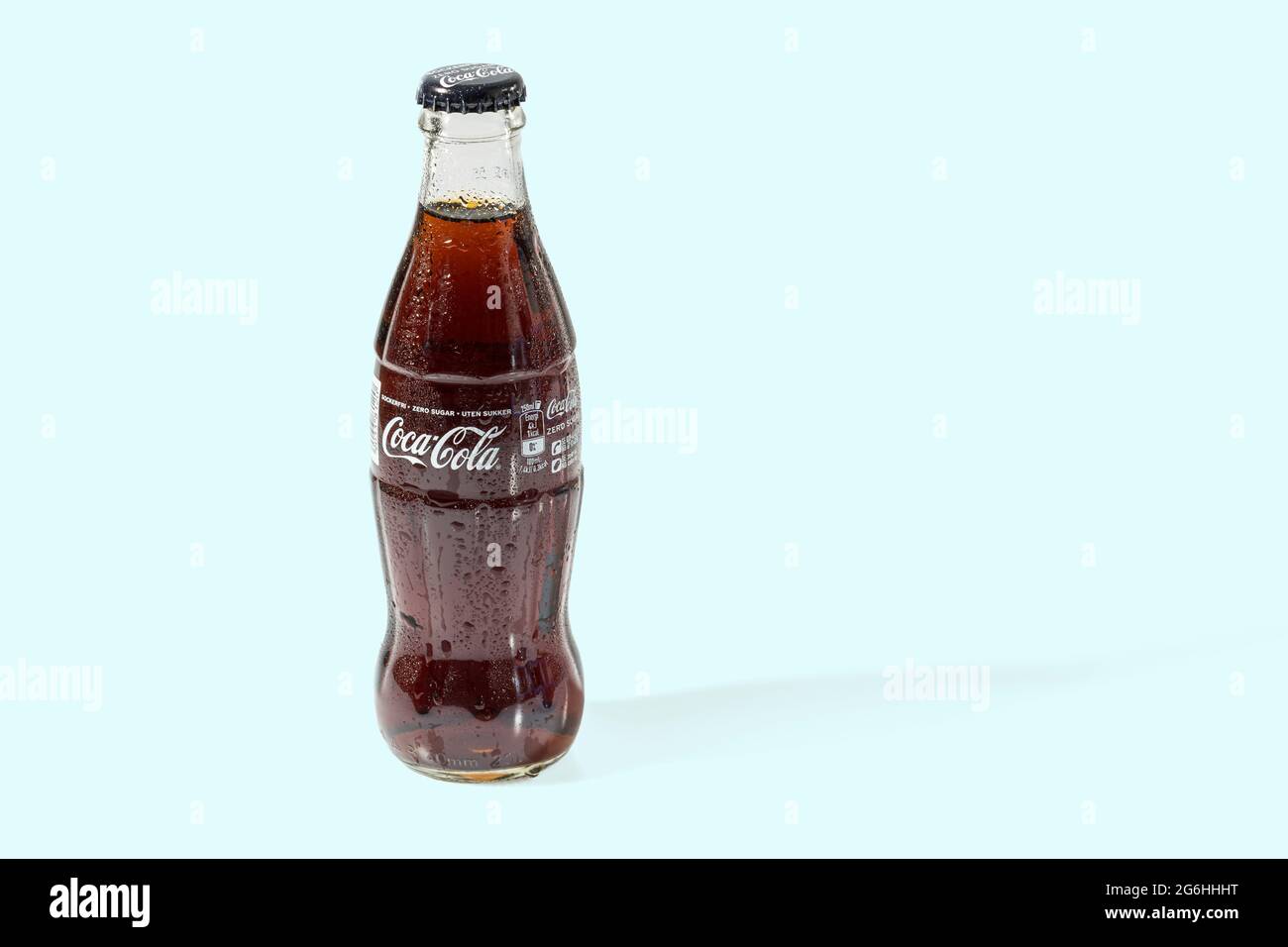Close up view of Coca Cola in a glass bottle isolated on blue ...