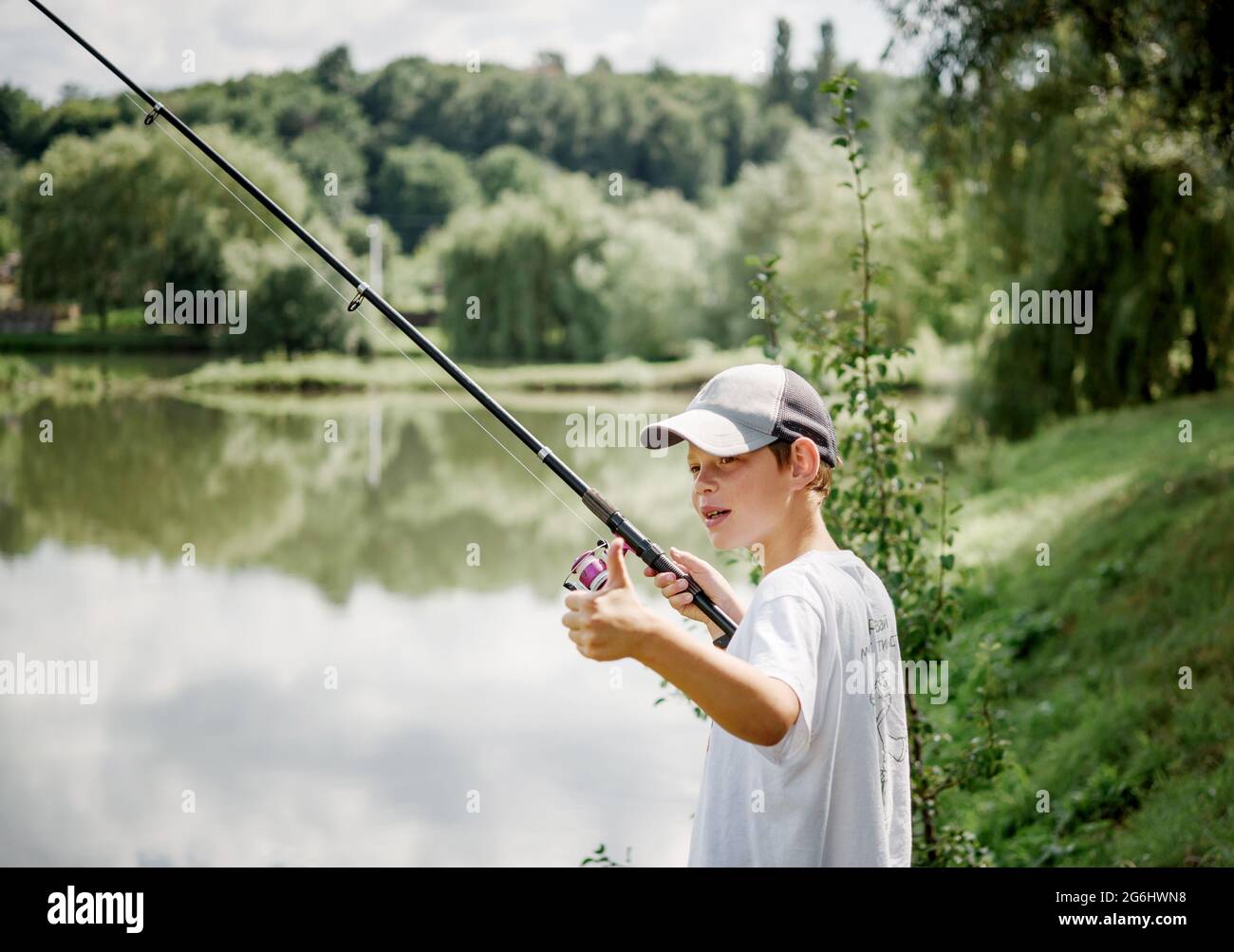 A boy fishing in the lake, summer activities and hobbies for children ...