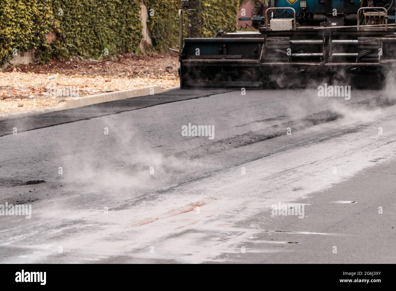 Street paving work with permanent asphalt, with smoke from the heat of ...