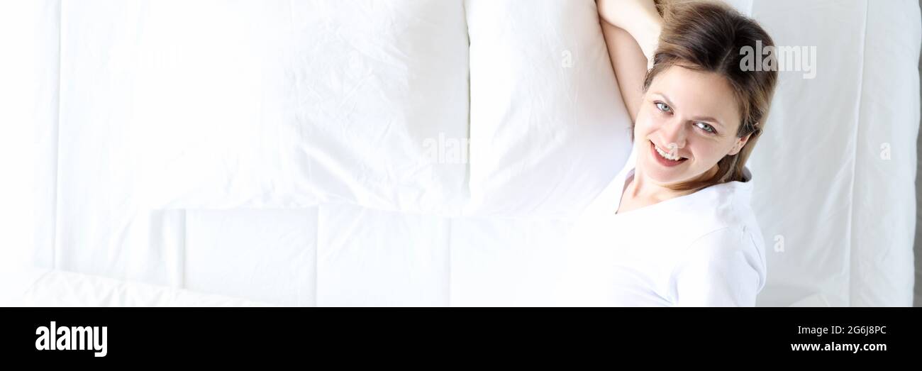 Young woman lying in bed and smiling top view Stock Photo - Alamy