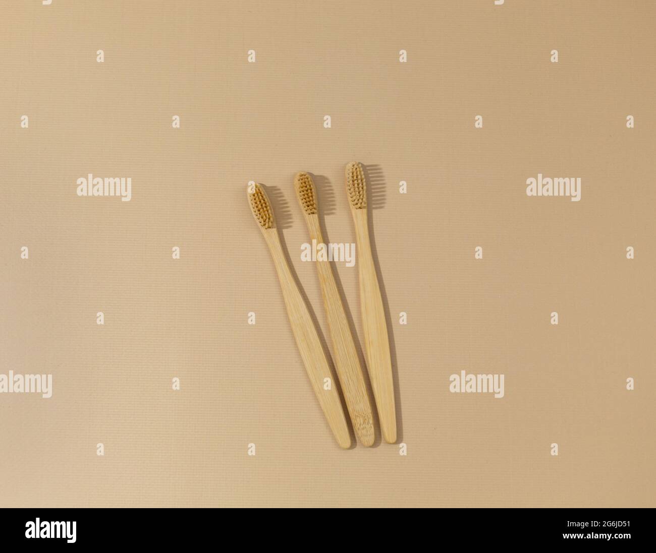 A set of eco-friendly bamboo toothbrushes on a beige pastel background ...
