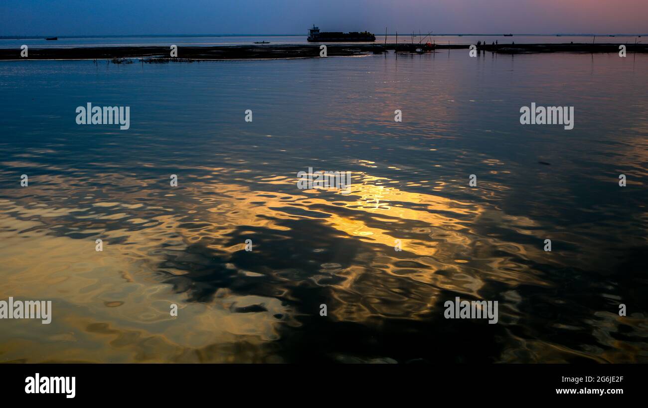 Beautiful view of the sun setting on the river bank. The sun's shadow ...