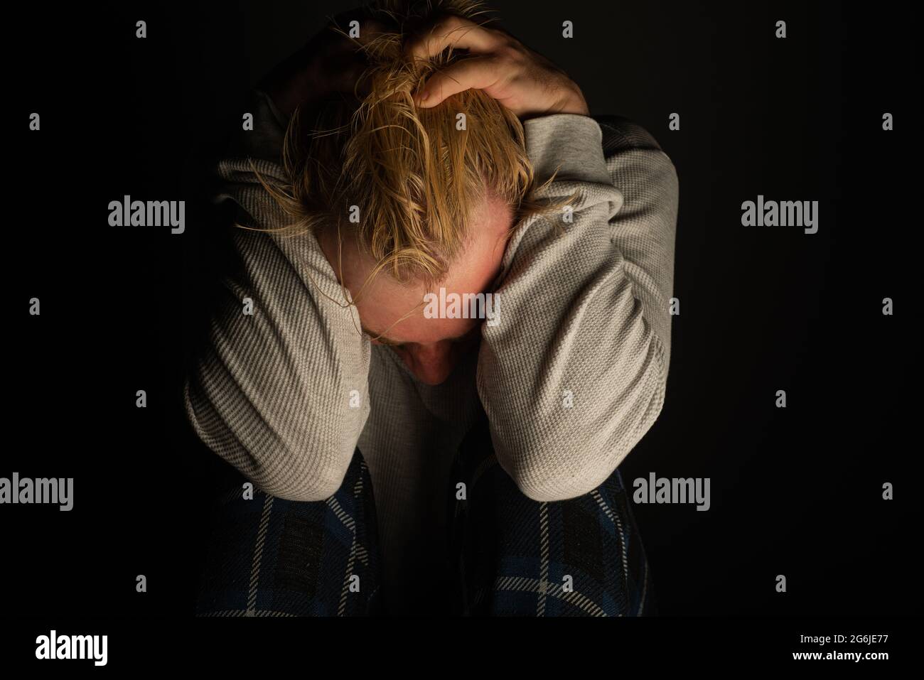 Broken boy is holding his head while suffering and crying a lot Stock ...