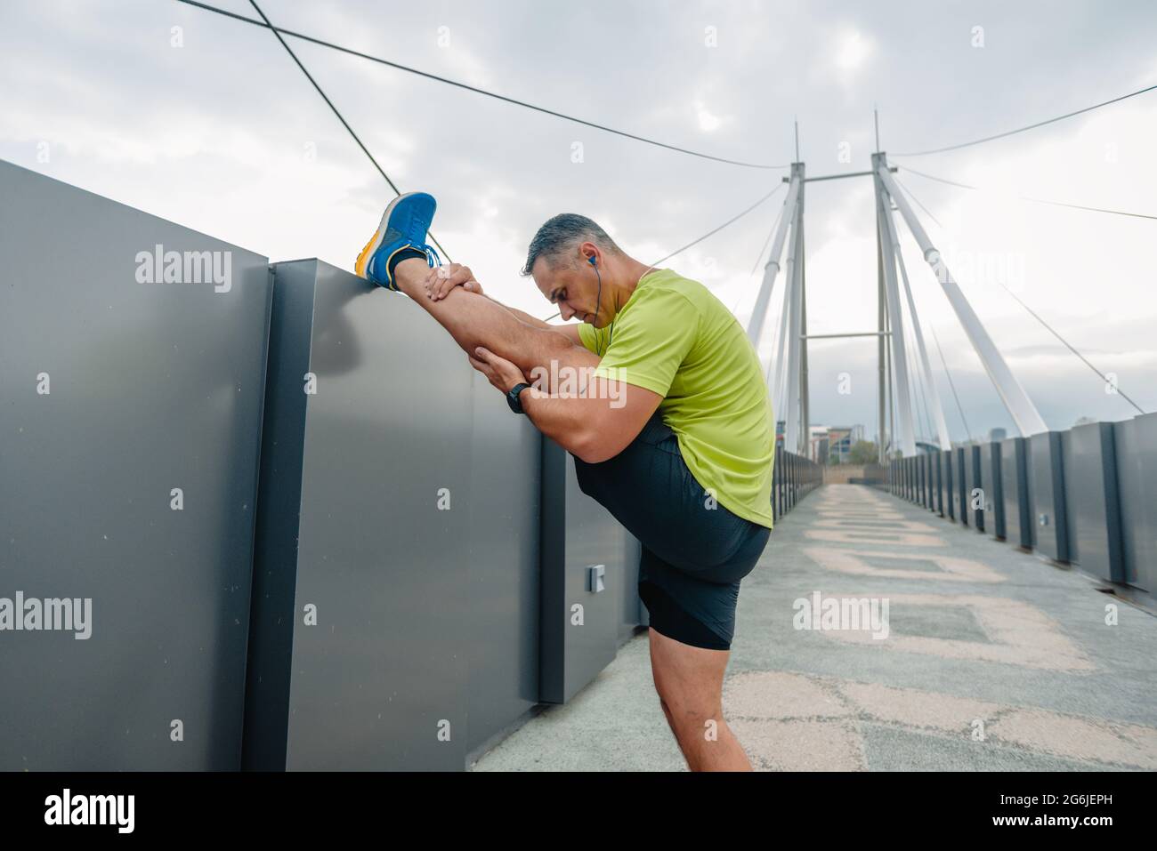Healthy fit middle aged runner during a warm up routine before running ...