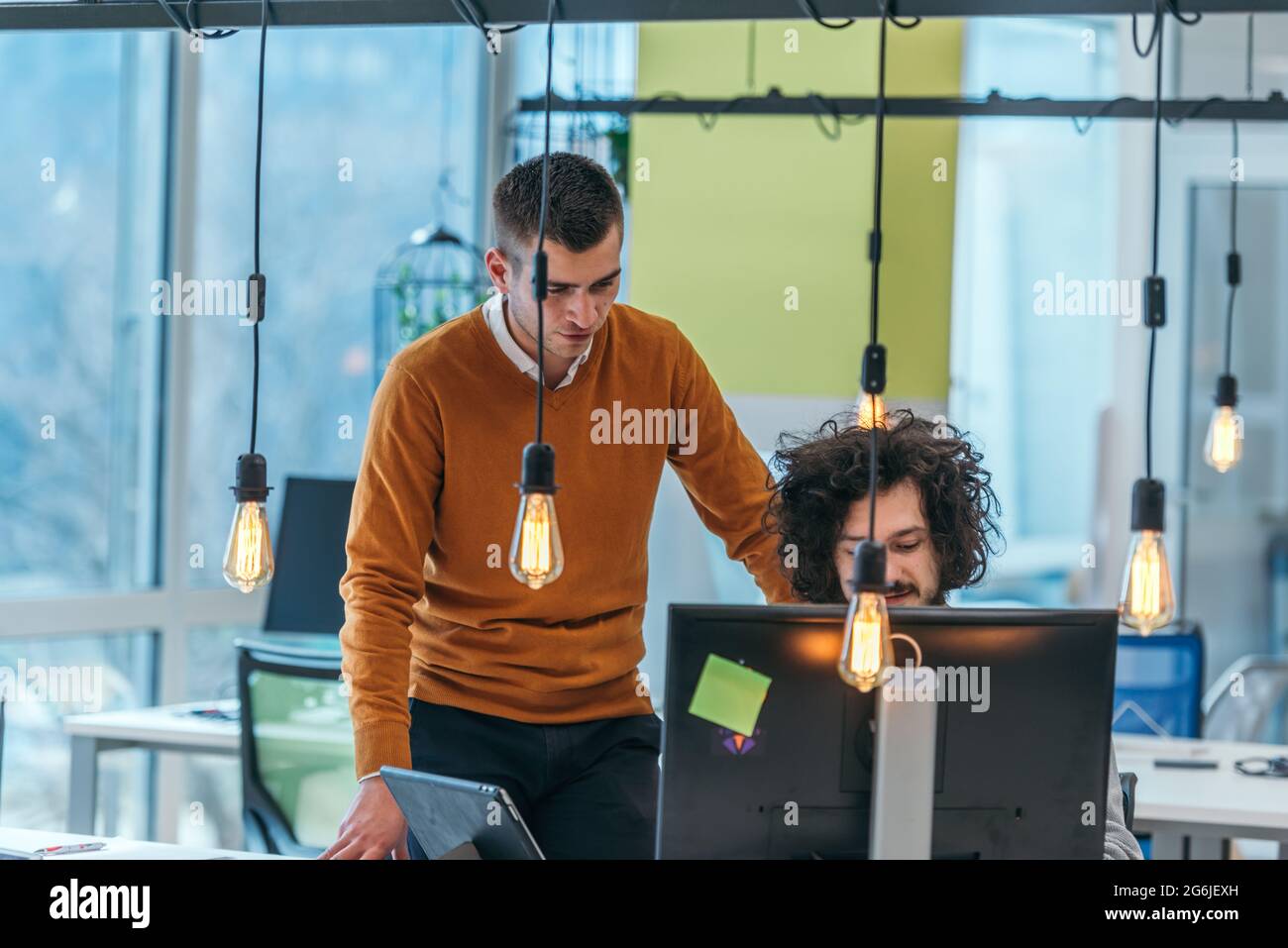 Portrait of two busy colleagues working on pc economy project on modern ...