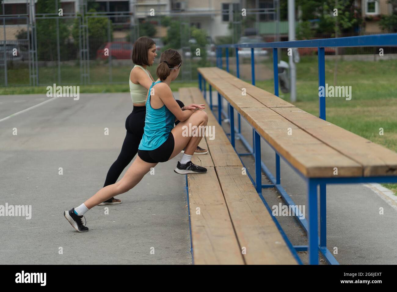 Two attractive and beautiful girls are doing some stretches on the ...