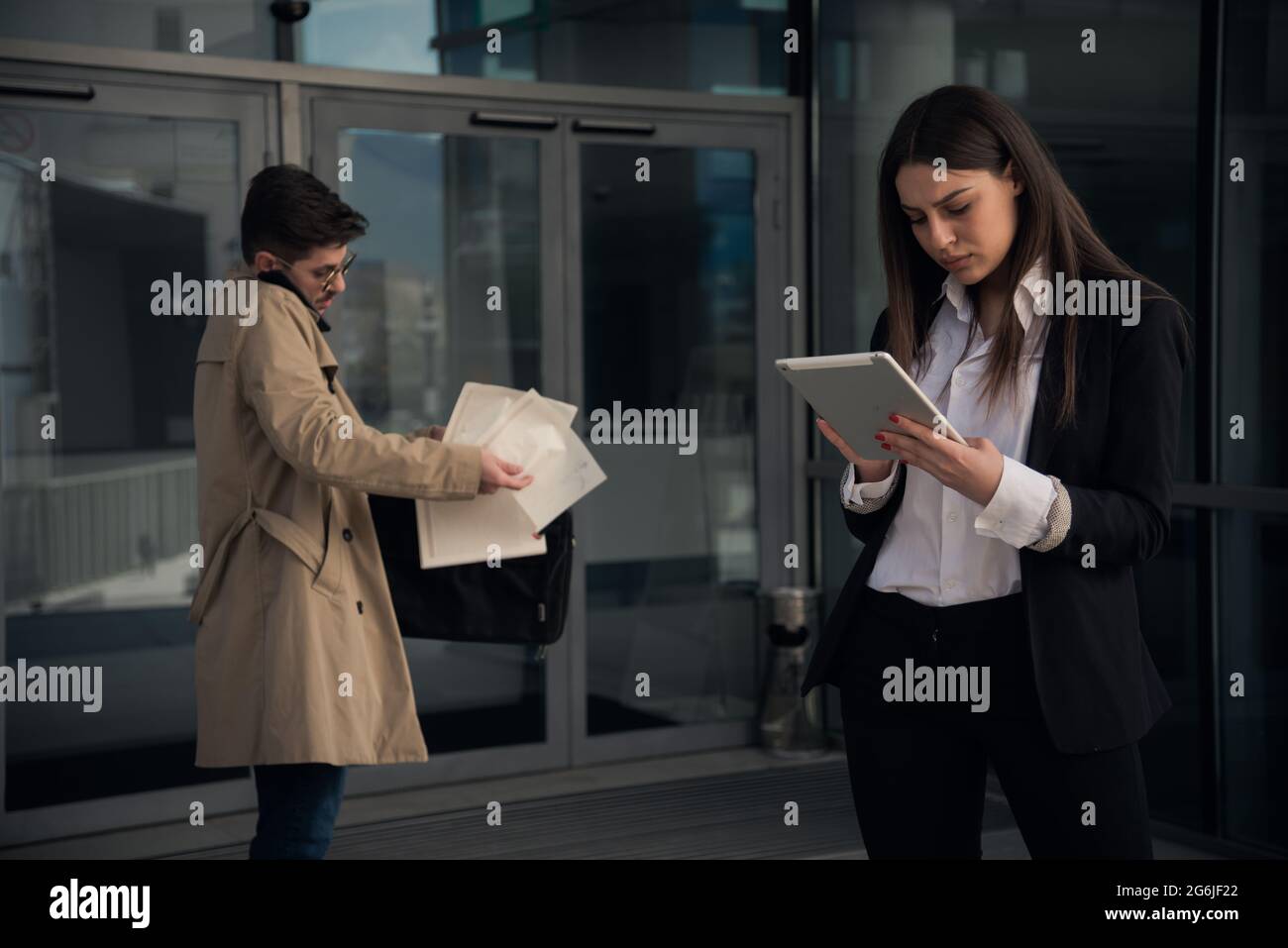 Female boss is waiting her assistent to finish his phone call about the ...