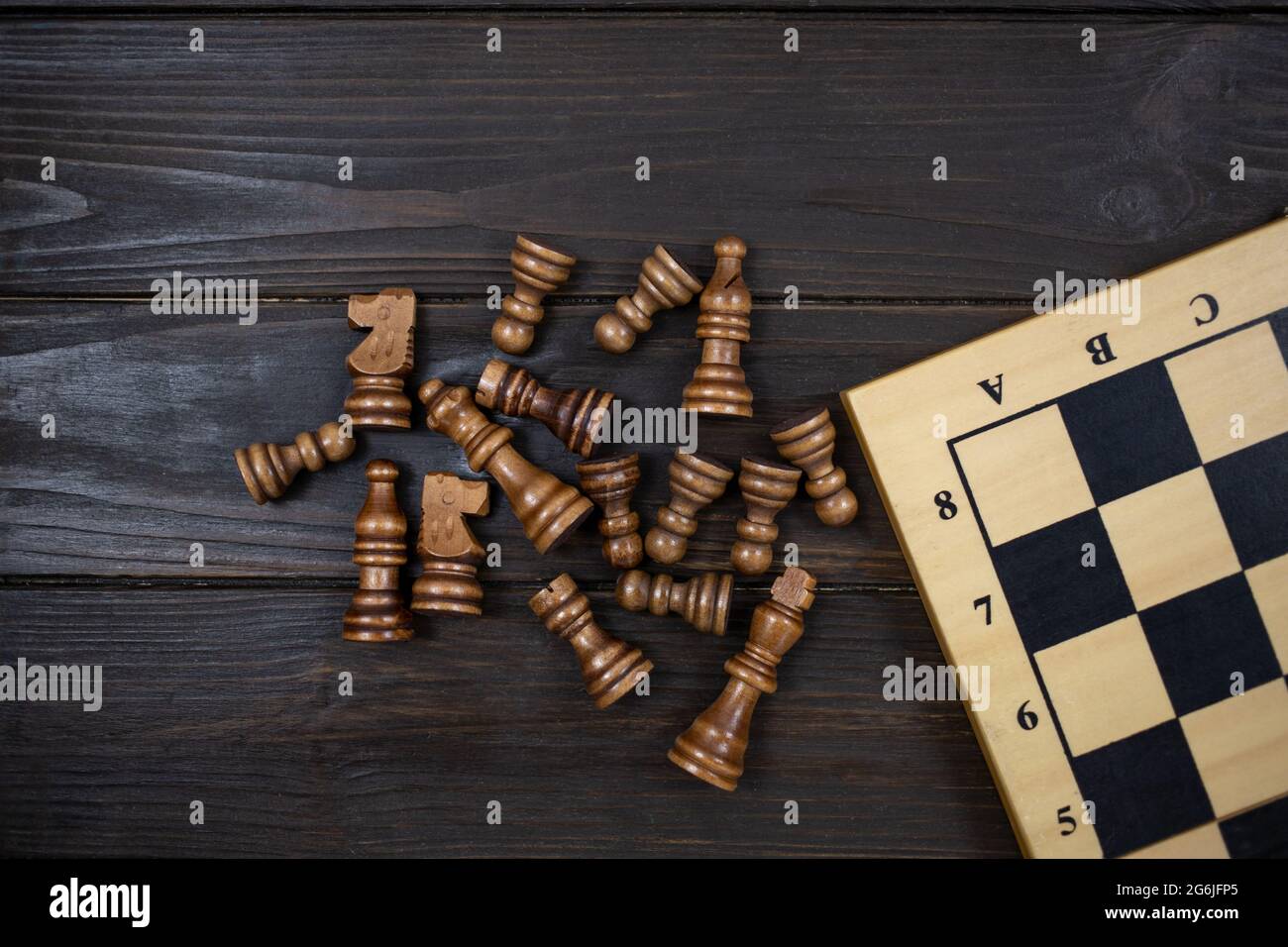 Chess board and chess figures on dark wooden table. Popular logic game ...