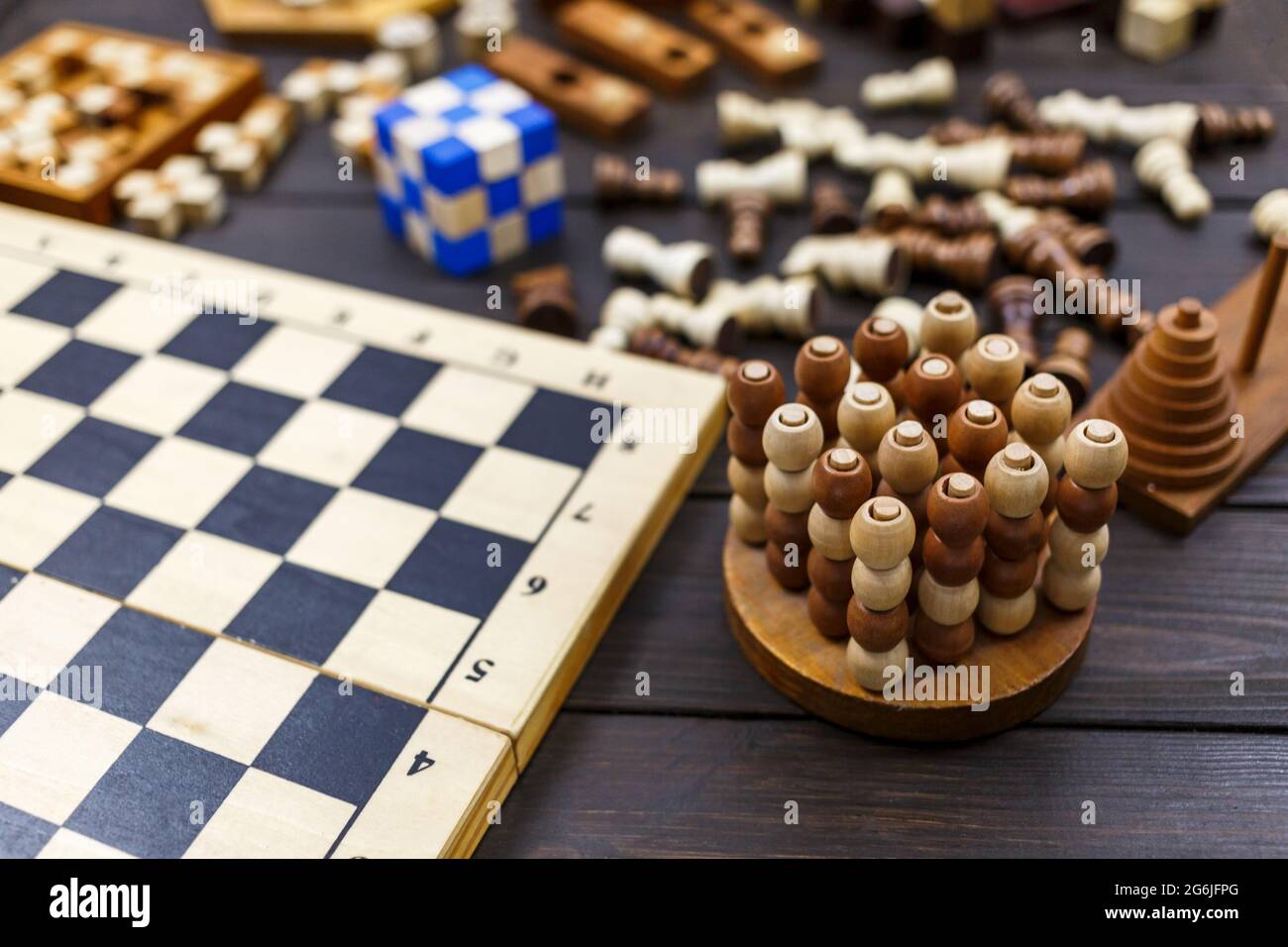 Chessboard and chess figures, wooden cubes, puzzle games on dark wooden ...