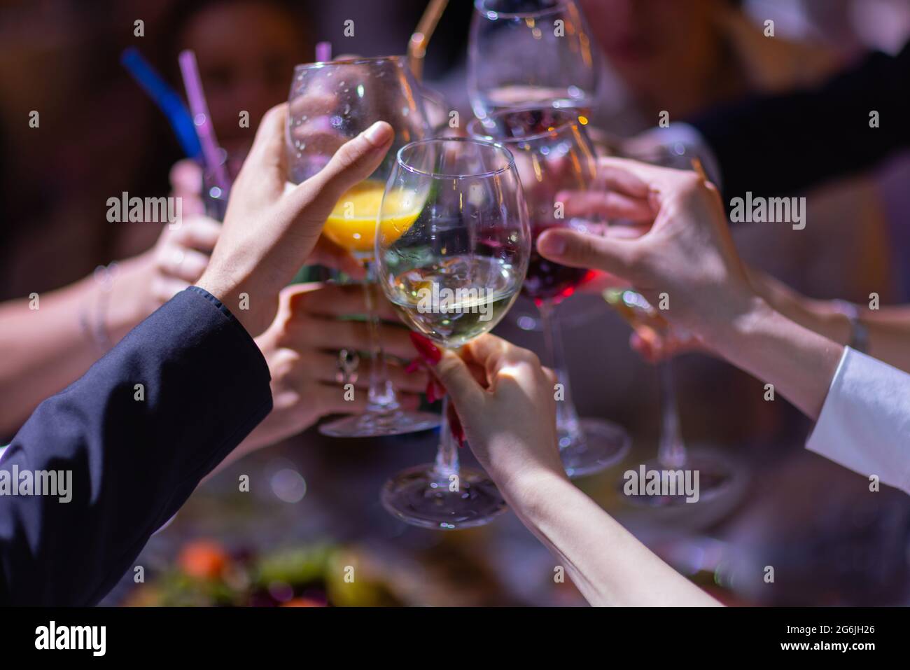 Clinking glasses with alcohol and toasting, party Stock Photo - Alamy