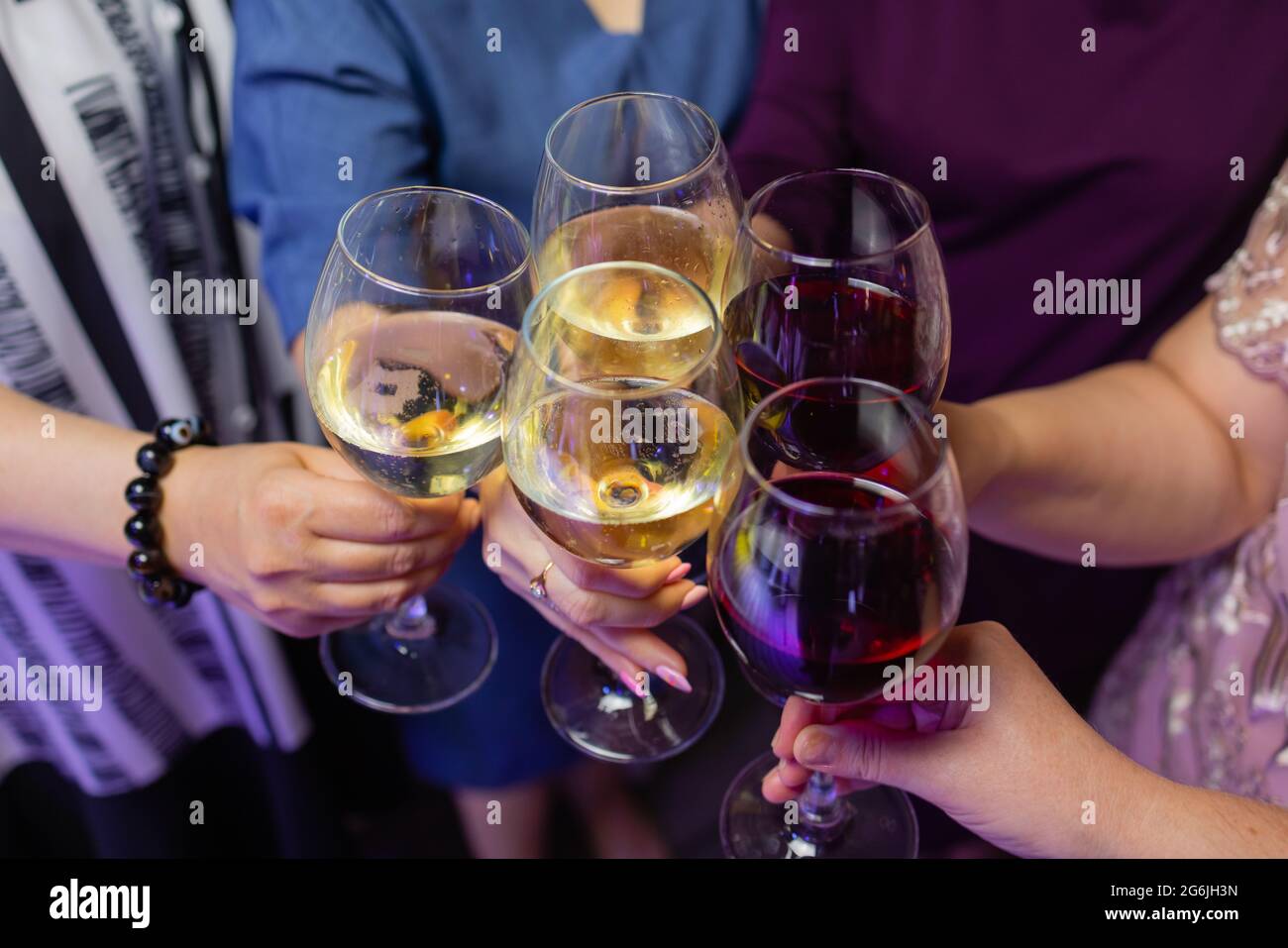 Clinking glasses with alcohol and toasting, party Stock Photo - Alamy