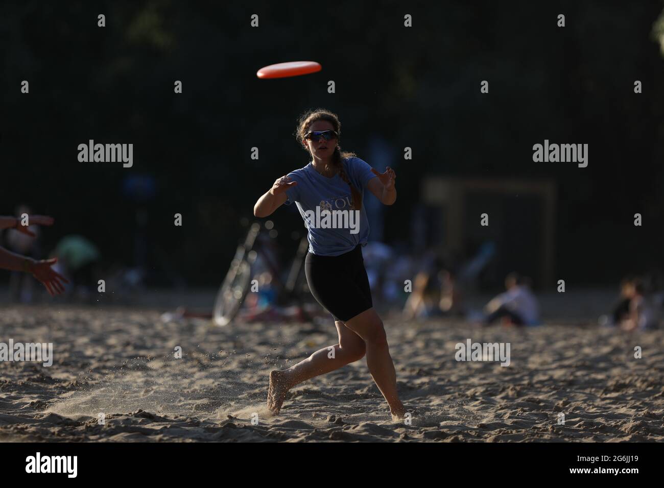 People are seen playing competitive frisbee at a beach in Warsaw ...