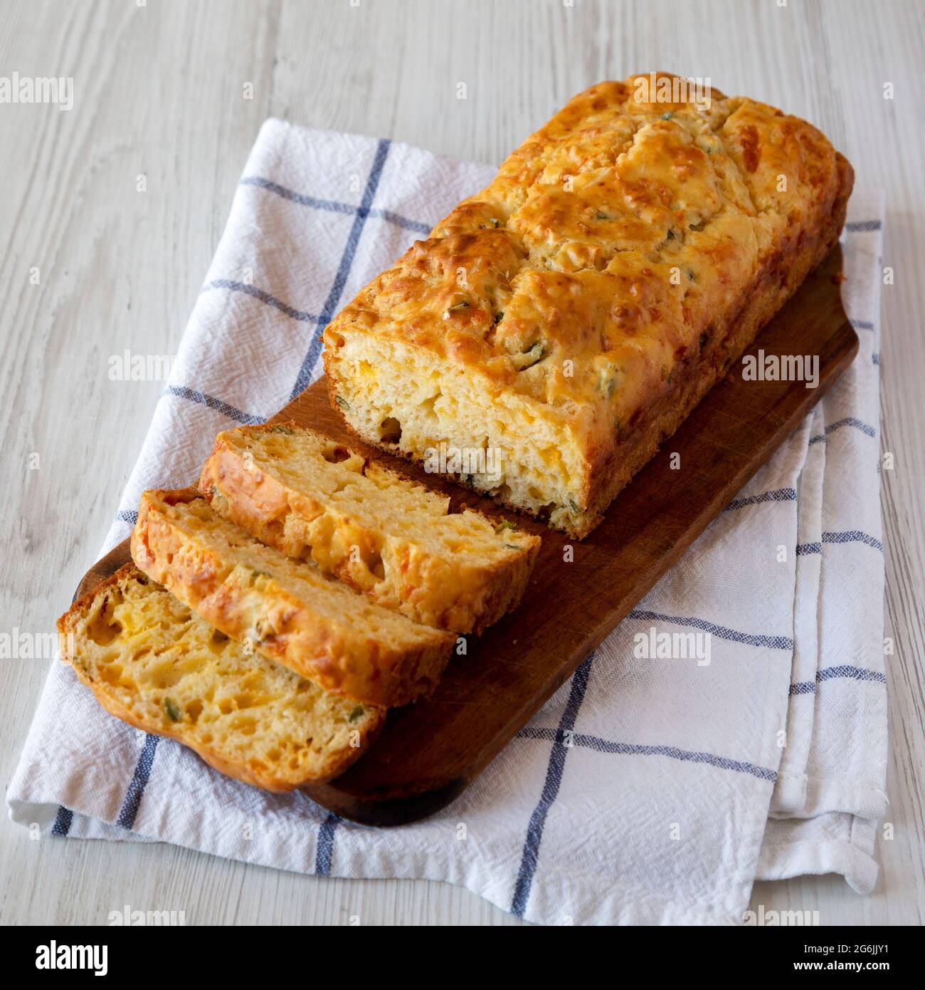 Homemade Cheesy Bread Loaf on a rustic wooden board on a white wooden ...