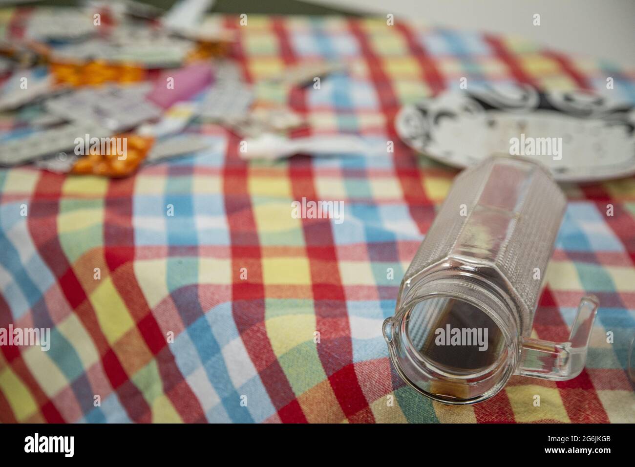 Closeup of a fallen coffee glass on a messy destroyed picnic table with ...