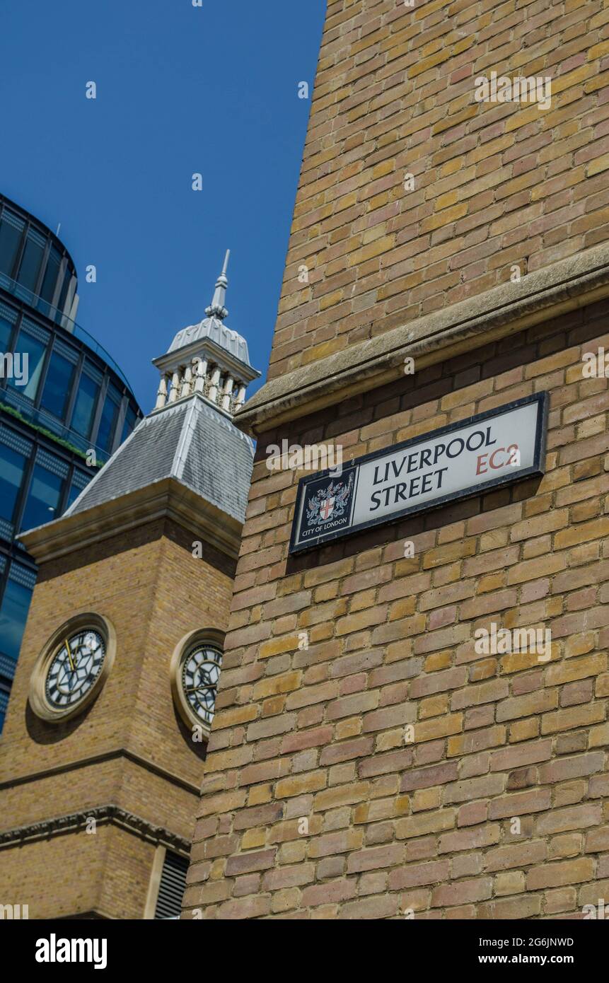 A street sign outside London Liverpool Street Station with a clock ...