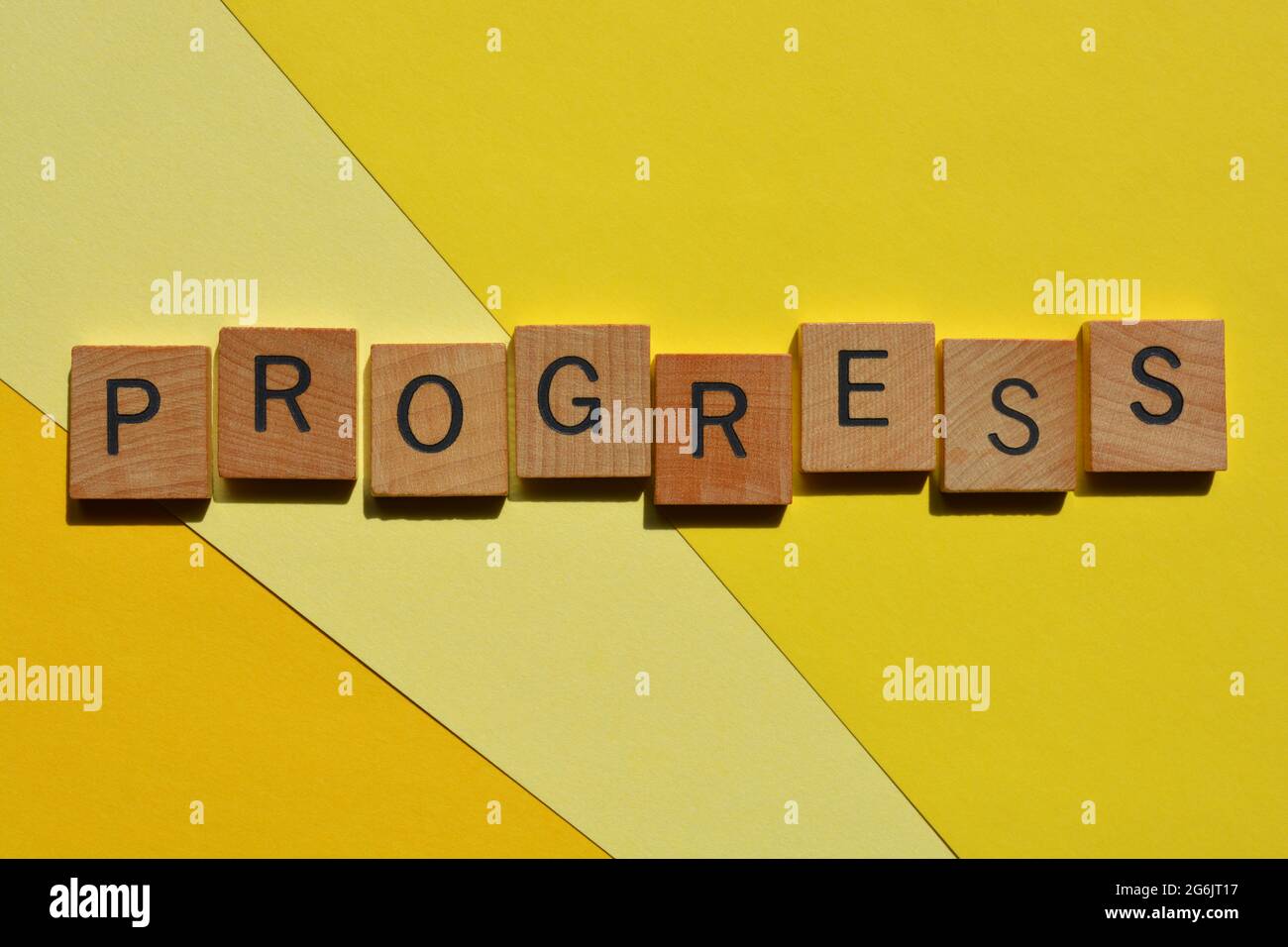 Progress, word in wooden alphabet letters isolated on yellow background ...