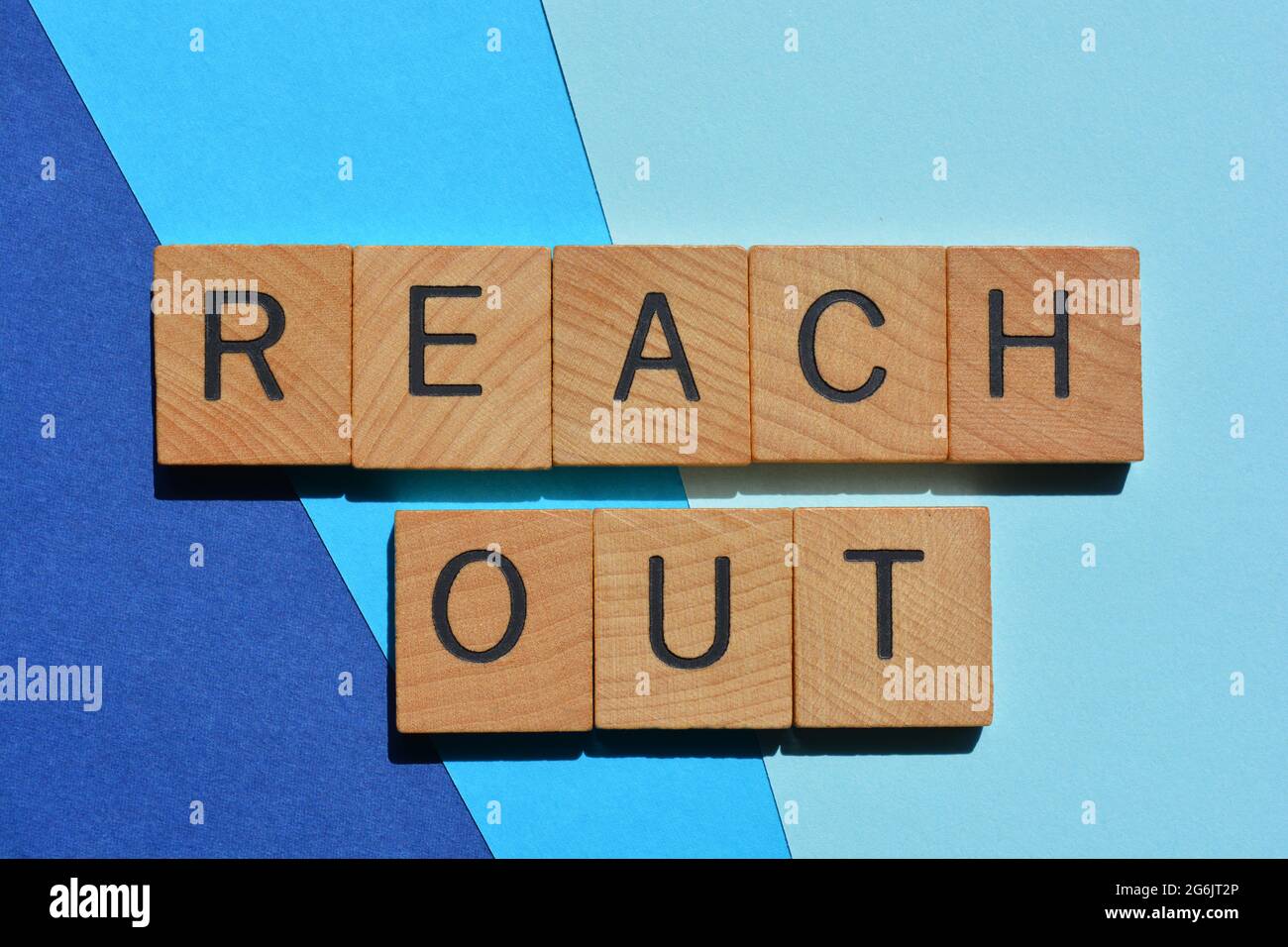 Reach Out, words in wooden alphabet letters isolated on blue background ...