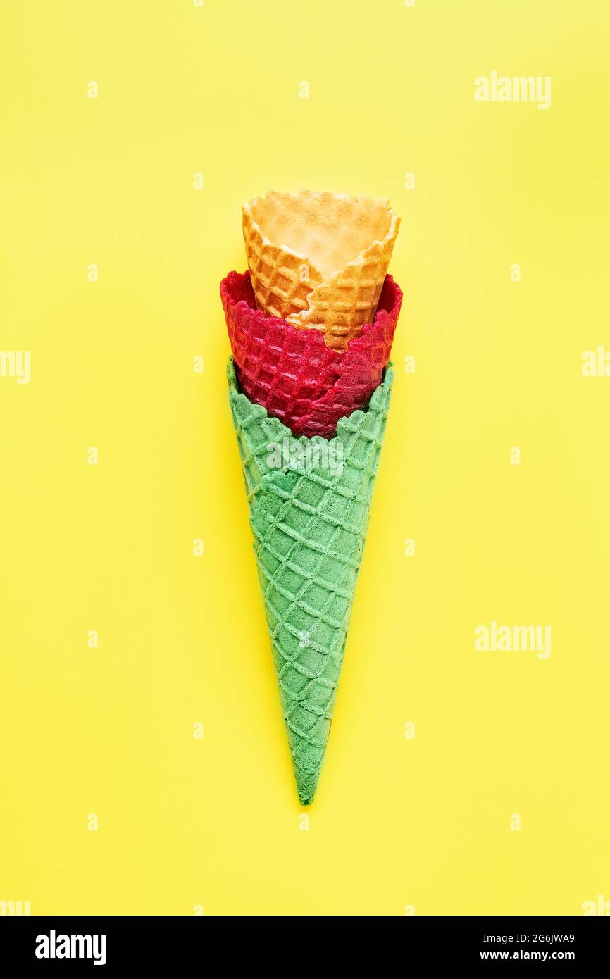 Various empty ice cream cones on a bright yellow background. Summer ...