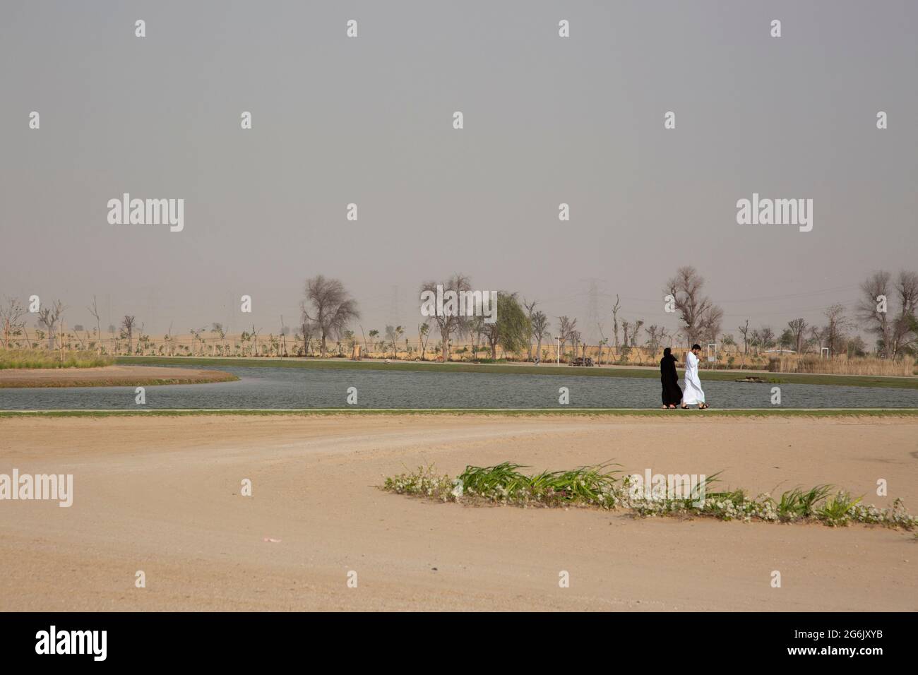 A couple walks along the Love Lakes in Al Qudra, Dubai, UAE. --- The ...