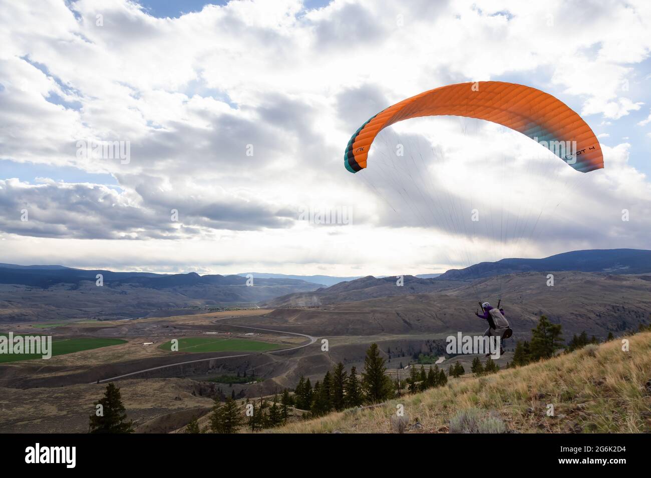 Adventurous Woman Flying on a Paraglider around the mountains Stock ...