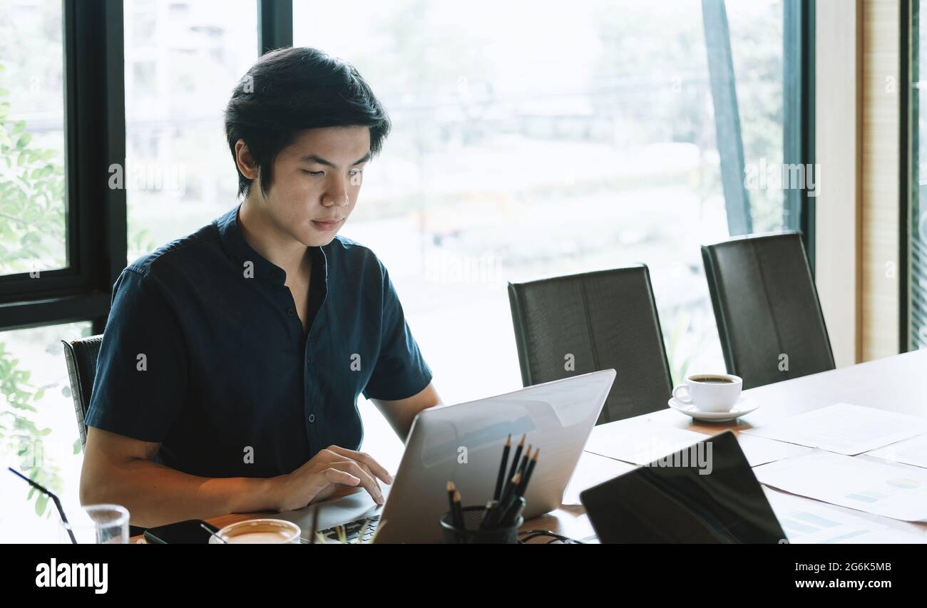 Young asian man working at home with laptop computer. Business ...