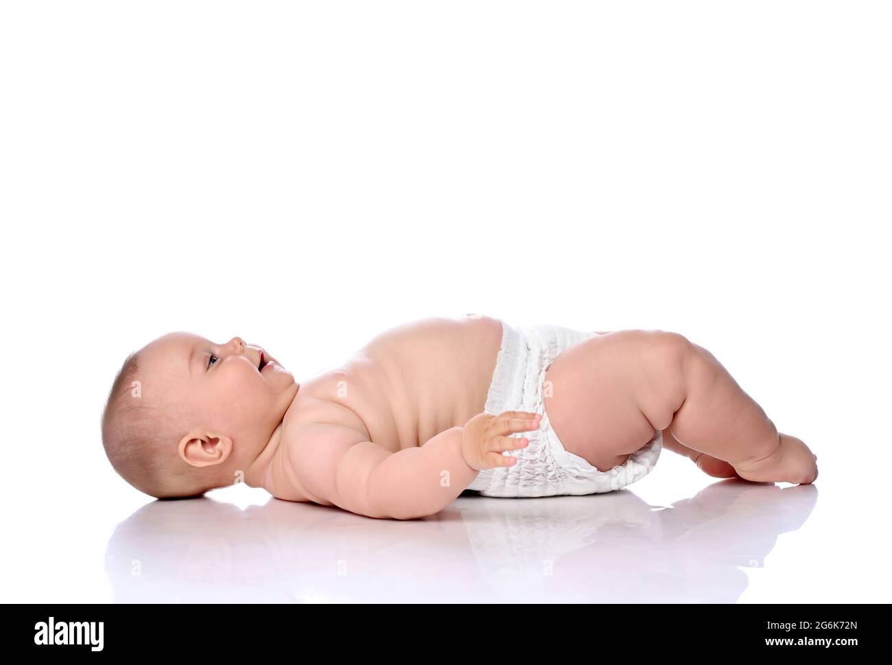 Infant child baby girl kid in diaper is lying on her back sideways to ...