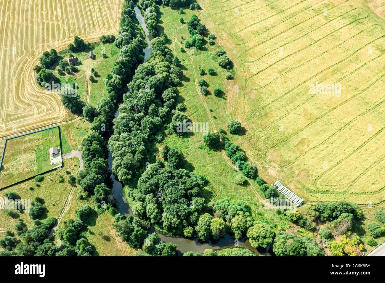 aerial view of rural area with farm fields and winding small river ...