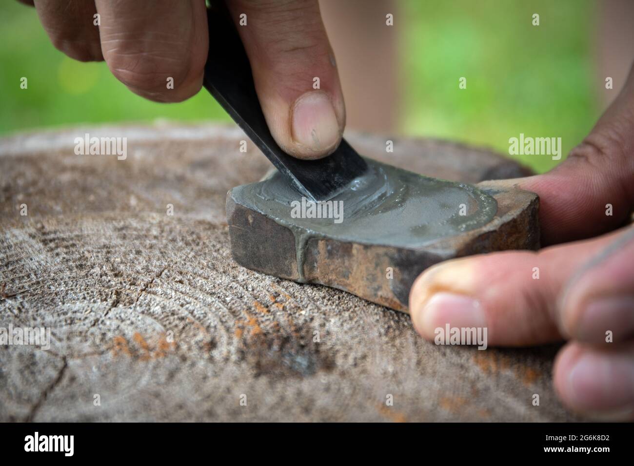 Manual sharpening of wooden chisel on a grinding stone. Craftsman works ...