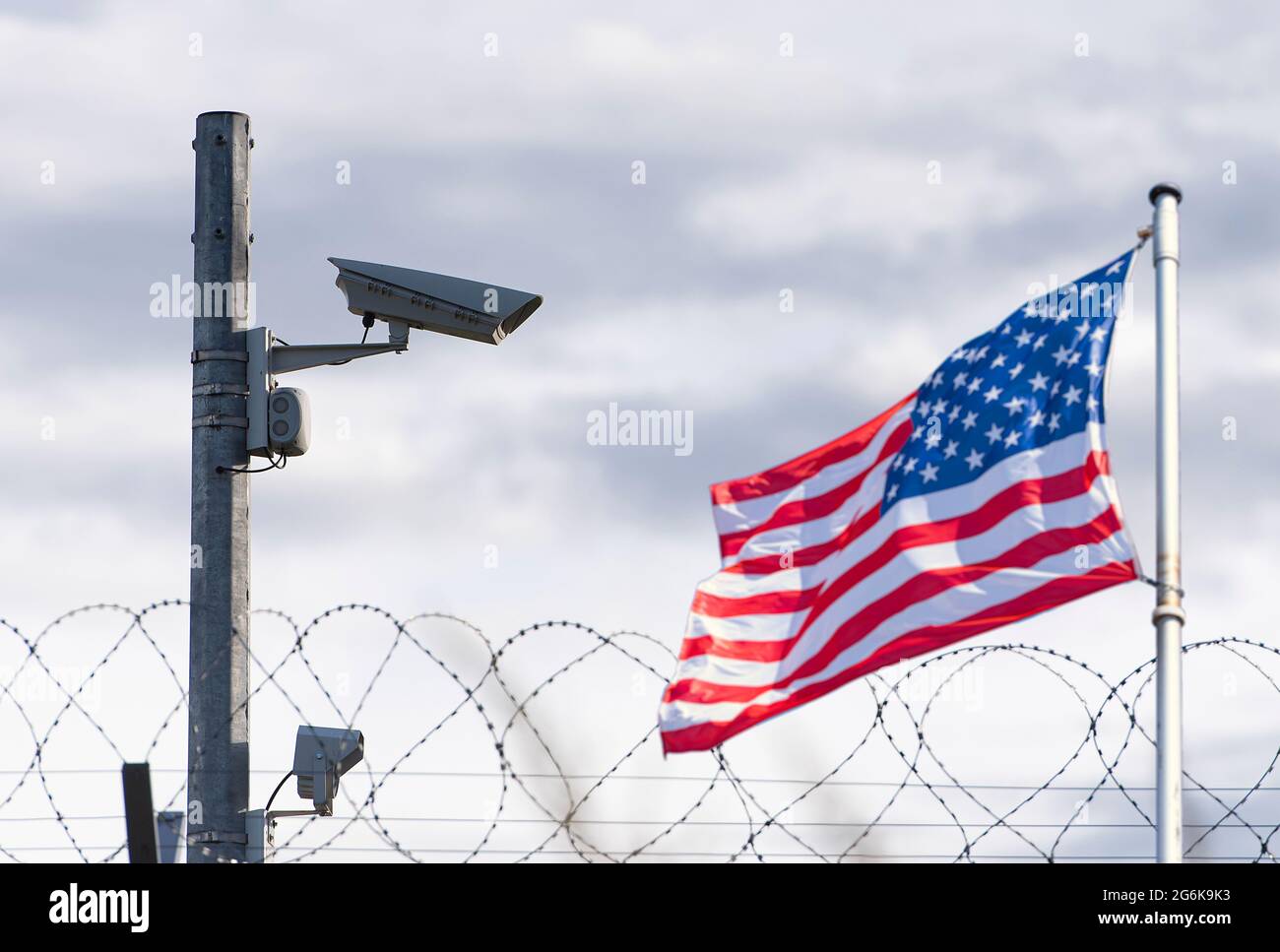 USA border, surveillance camera, barbed wire and USA flag, concept ...