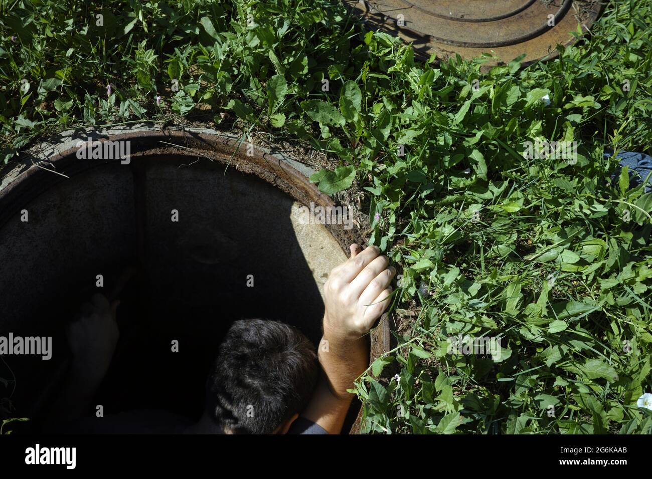 a worker going down into a manhole for inspection,outdoor shot Stock ...