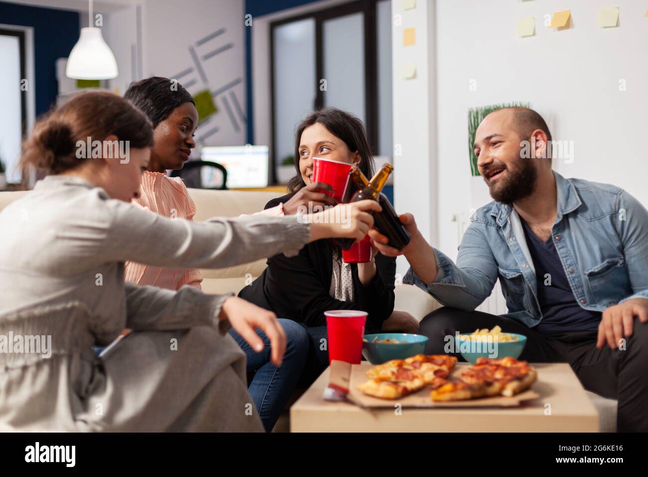 Diverse group of workers having fun after work at office meeting party ...