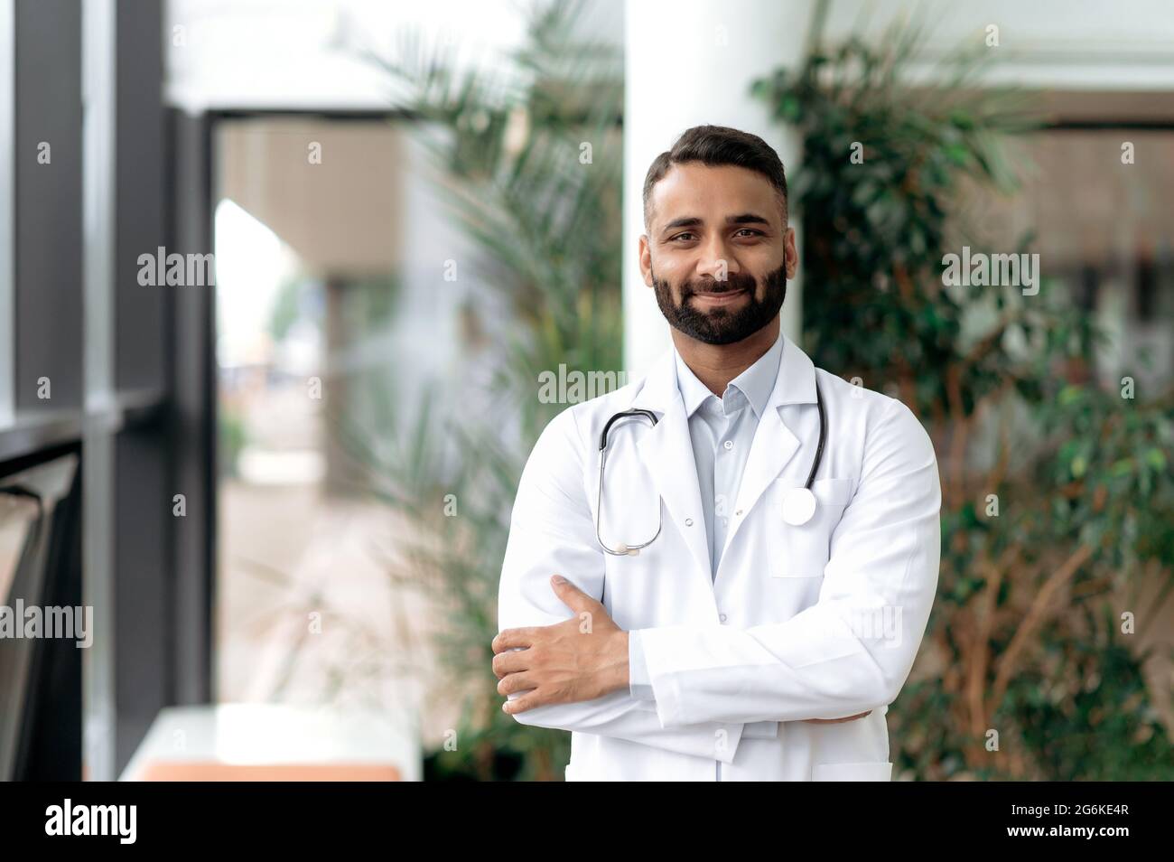 Portrait of an Indian general medicine doctor, stands with arms crossed ...