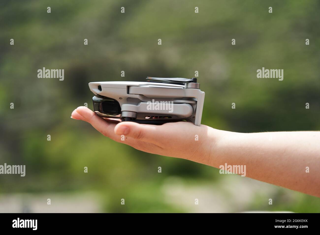 Modern small compact quadcopter in a girl's hand. Launching a drone ...