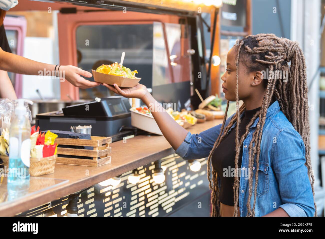 Afro american woman receiving a fast food tray with guacamole and ...