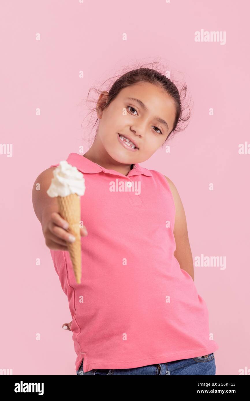 Generous little girl offering an ice cream cone at the camera Stock ...